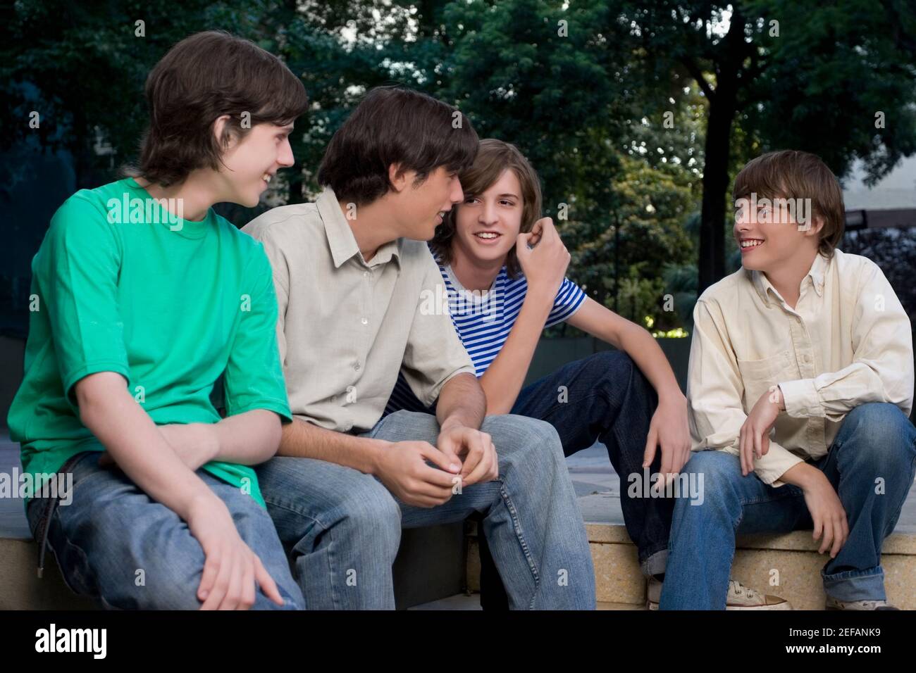 Four friends sitting together Stock Photo - Alamy