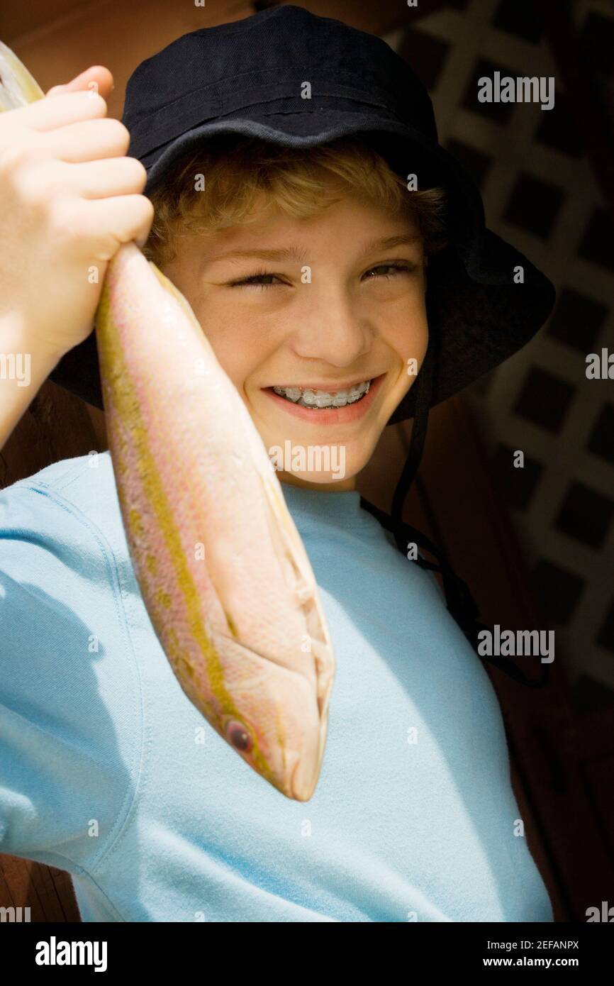 Portrait of a teenage boy holding a fish Stock Photo - Alamy