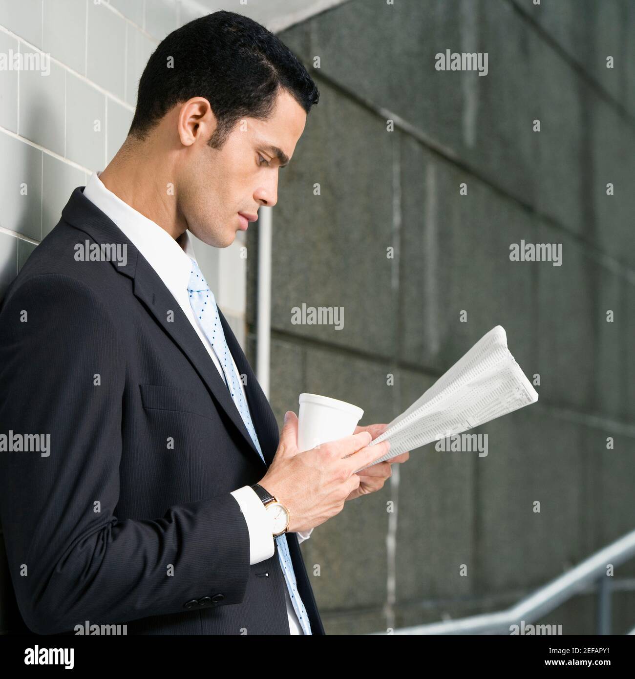 Side profile of a businessman reading a newspaper Stock Photo - Alamy