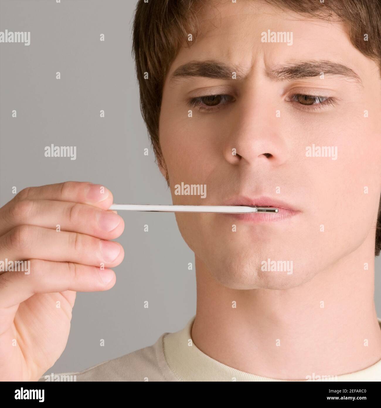 Close up of a young man checking the temperature on a thermometer Stock ...