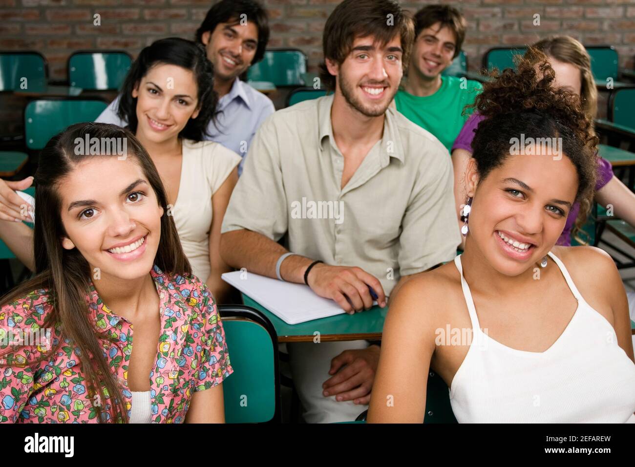 Portrait of university students sitting in a classroom and smiling ...