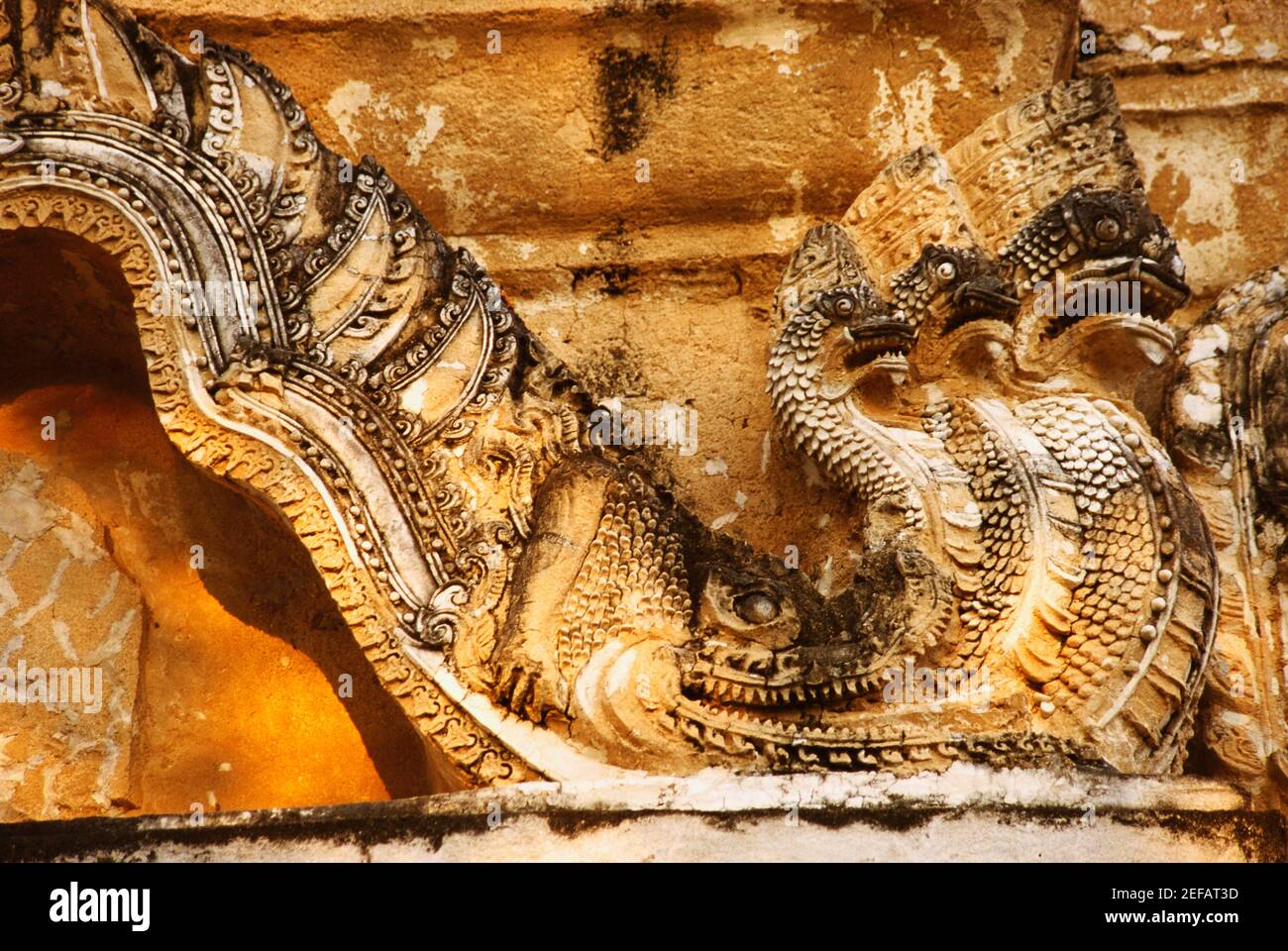 Close-up of a multi-headed dragon carved on a stone wall, Wat Si Sawai ...
