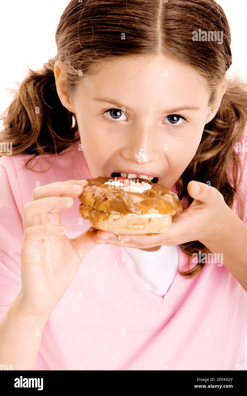 Portrait of a girl eating a donut Stock Photo - Alamy