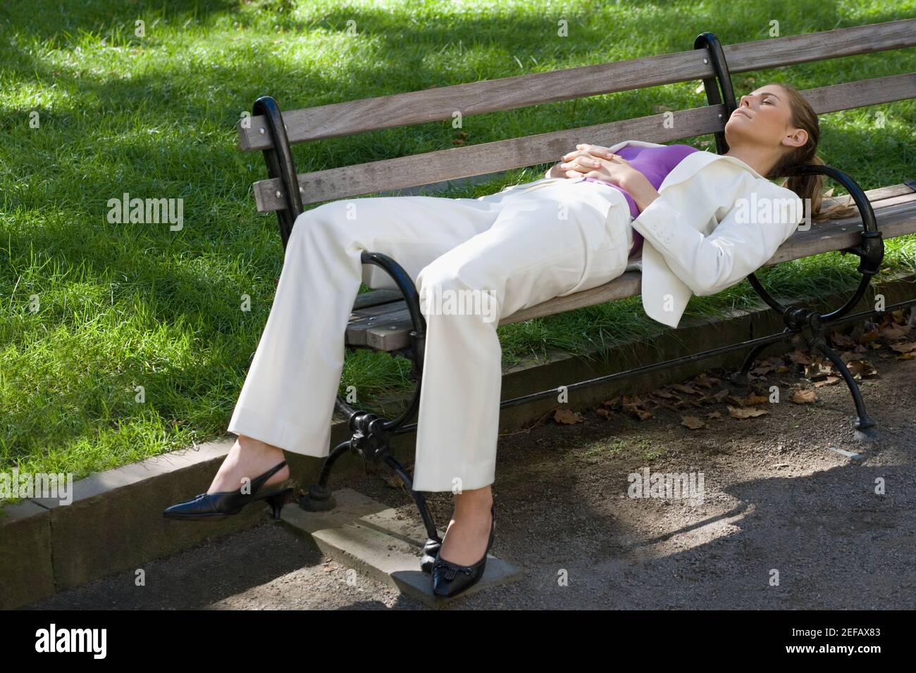 Woman sleeping on park bench hi-res stock photography and images - Alamy