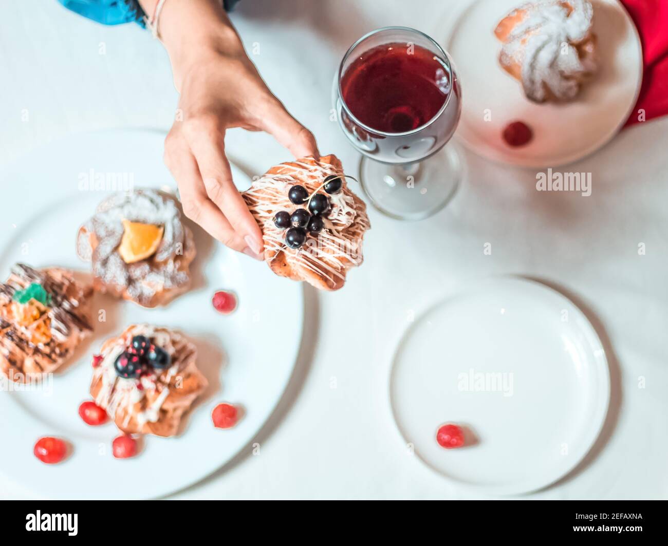 Top view of a female's hand holding traditional French eclair or ...