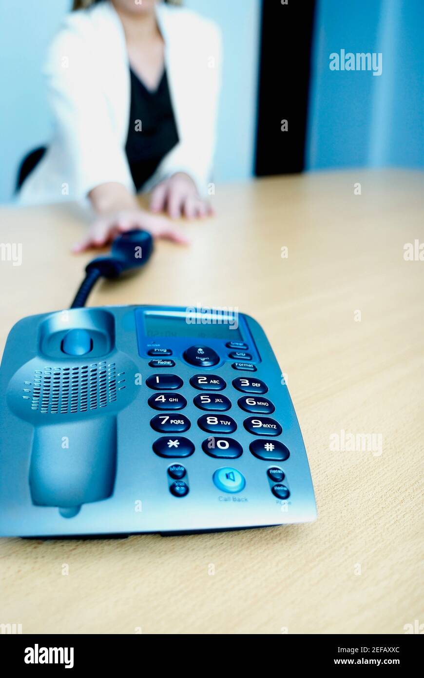 Mid section view of a woman reaching towards a telephone receiver Stock ...