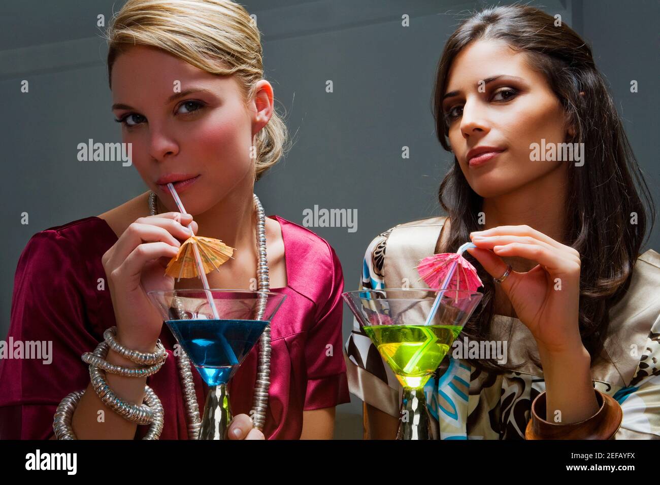 Portrait of two young women drinking cocktail Stock Photo - Alamy