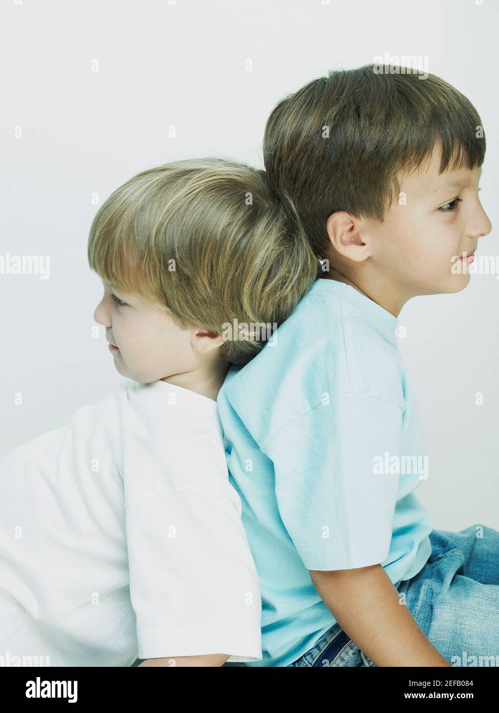Side profile of two boys sitting back to back Stock Photo - Alamy
