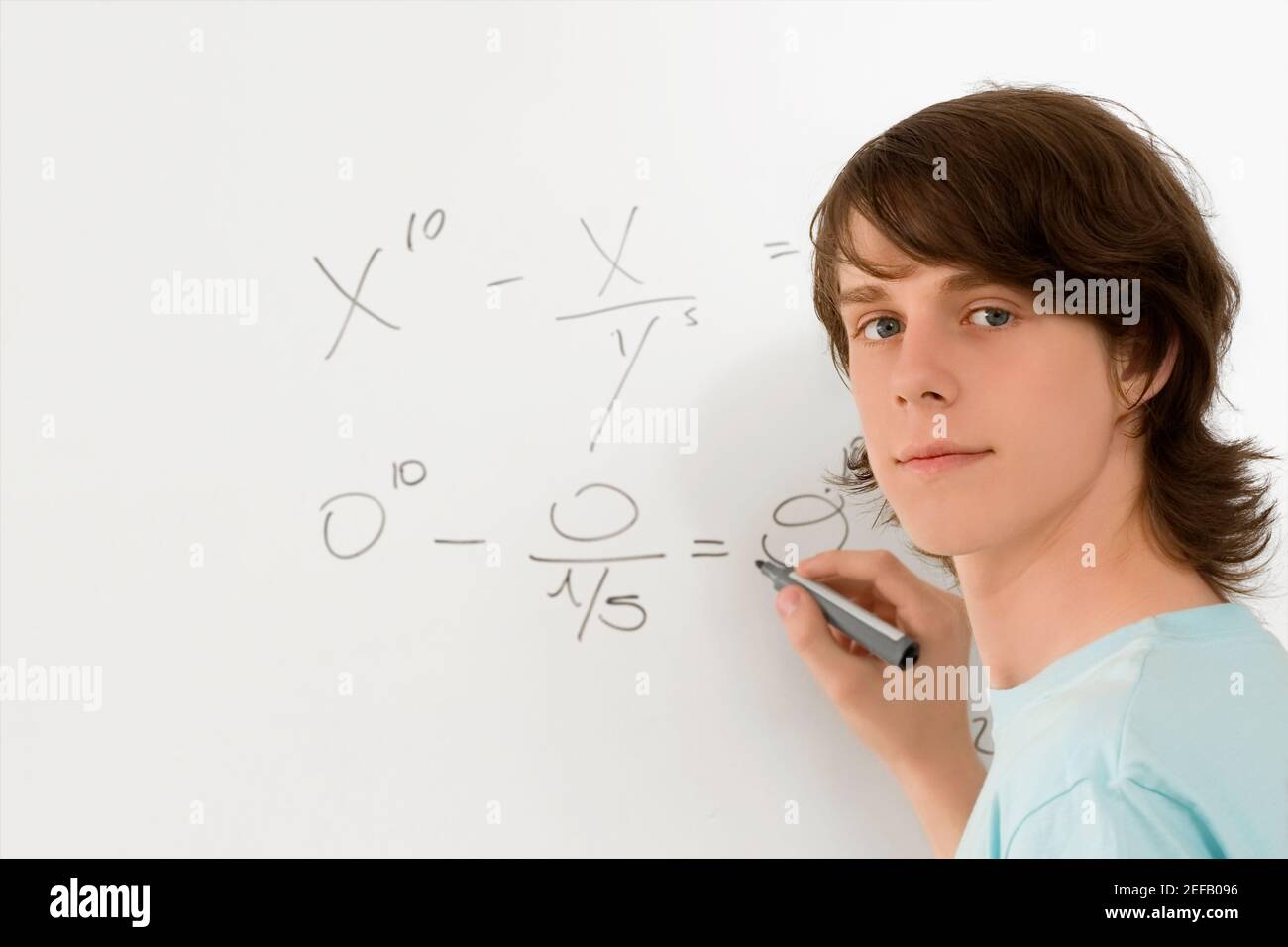Portrait of a teenage boy writing on a whiteboard Stock Photo - Alamy