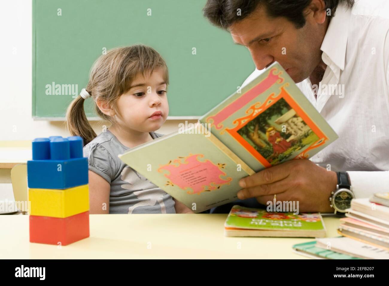 Male teacher teaching his student in a classroom Stock Photo - Alamy
