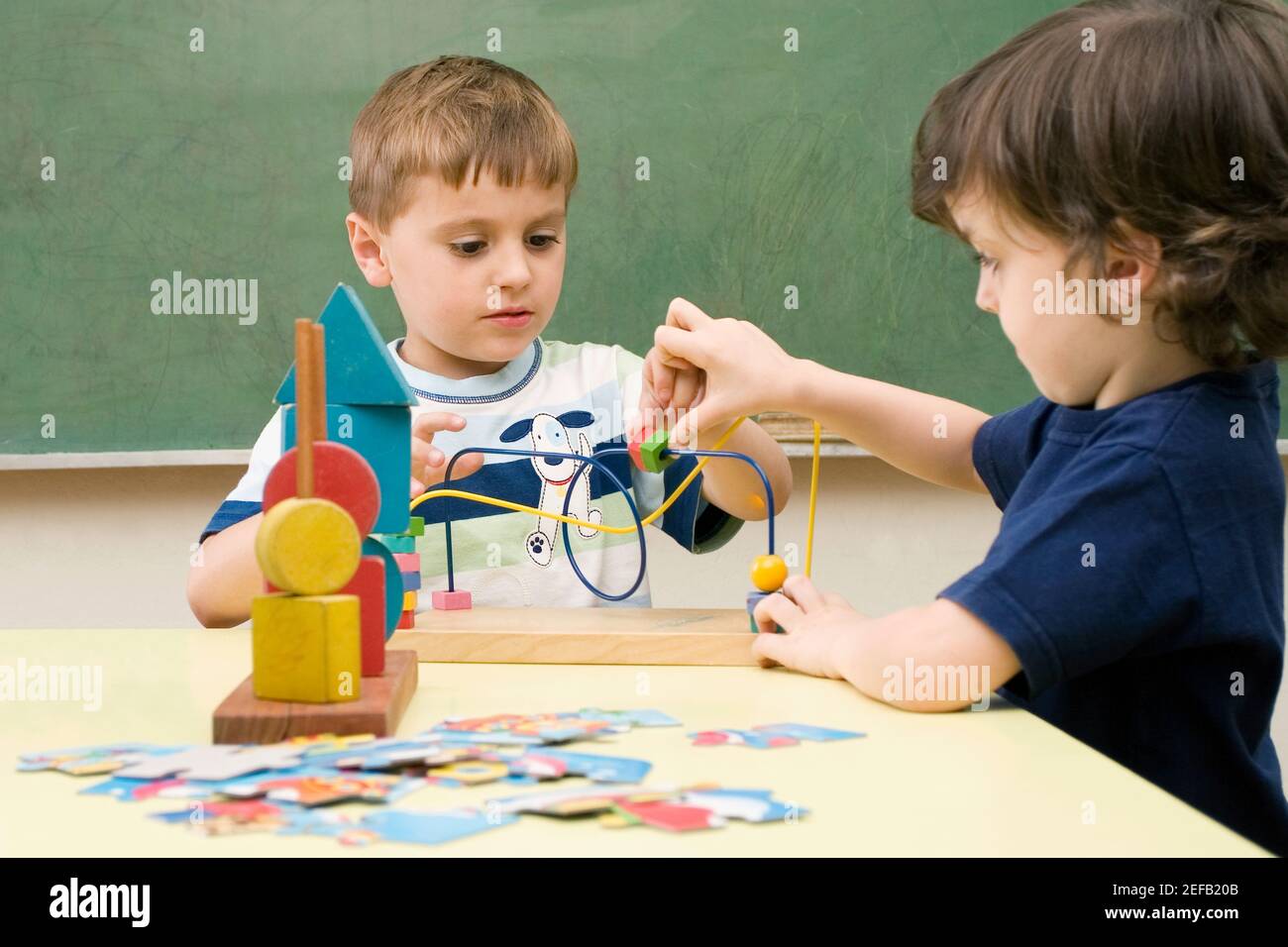 Two boys playing with a buzz wire game Stock Photo - Alamy