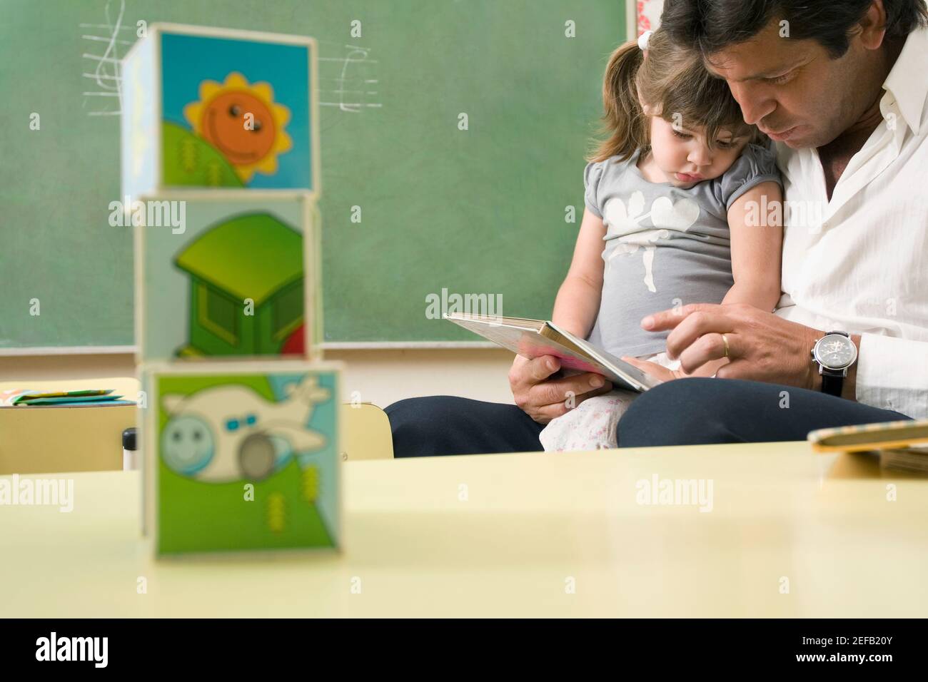 Male teacher teaching his student in a classroom Stock Photo - Alamy