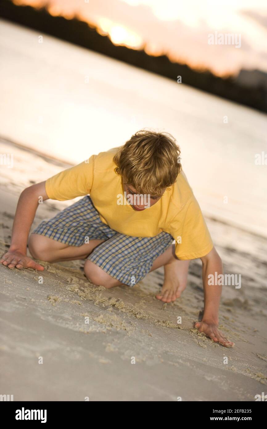 Boy kneeling in sand hi-res stock photography and images - Alamy