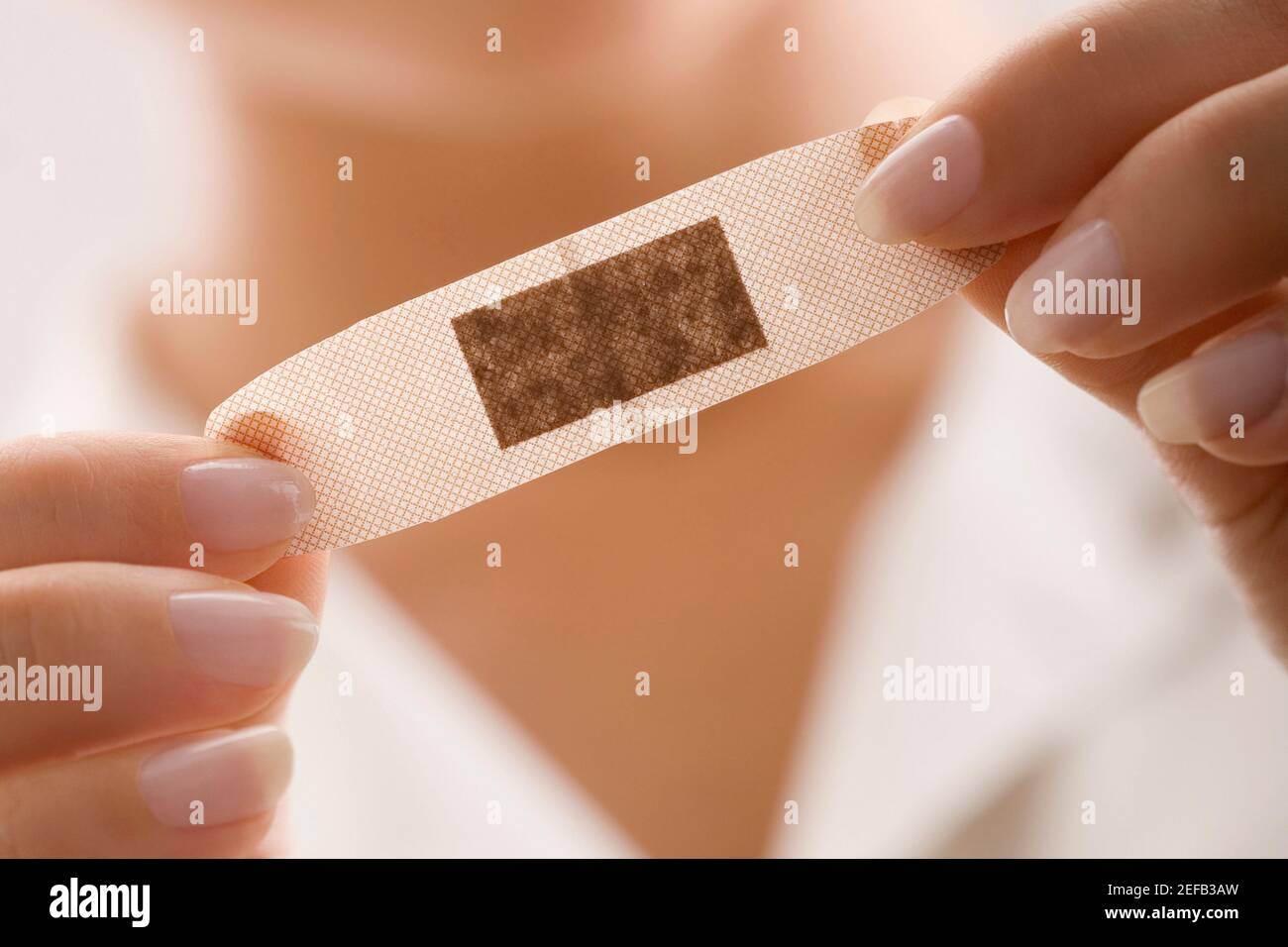 Mid section view of a female doctor holding an adhesive bandage Stock ...