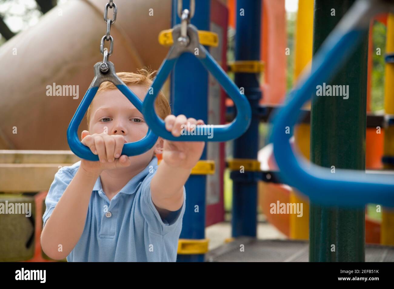 Portrait of a boy playing on monkey bars Stock Photo - Alamy