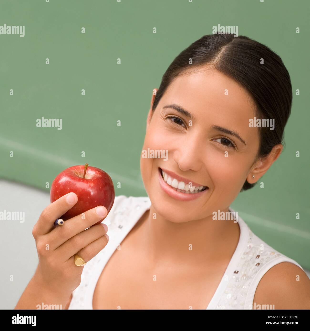 Portrait of a female teacher holding an apple and smiling Stock Photo ...