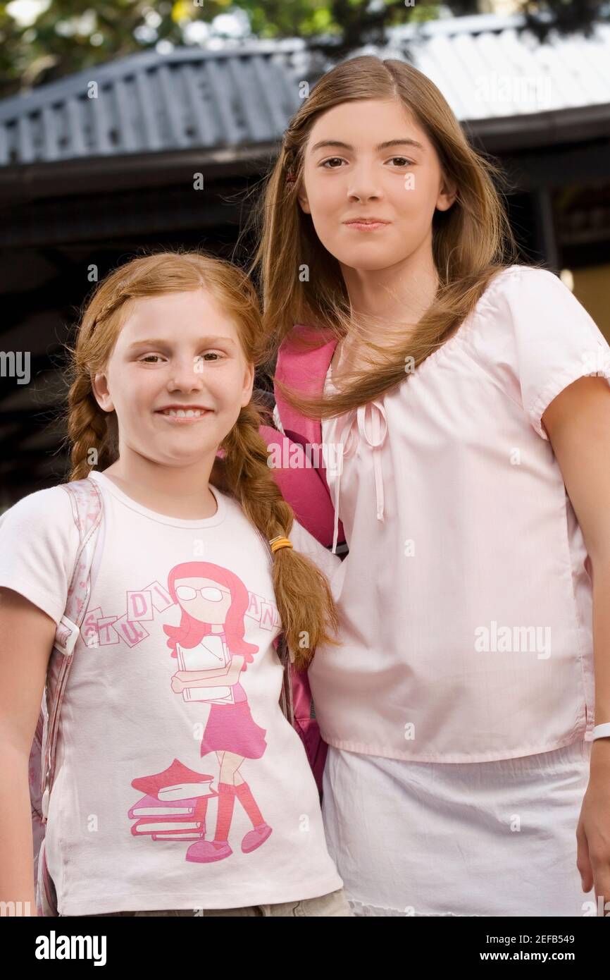 Portrait of two schoolgirls standing and smiling together Stock Photo ...