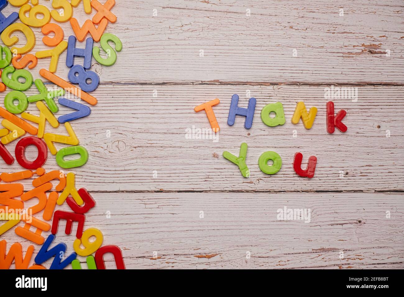 Colourful magnetic letters on a rustic white table during home school ...