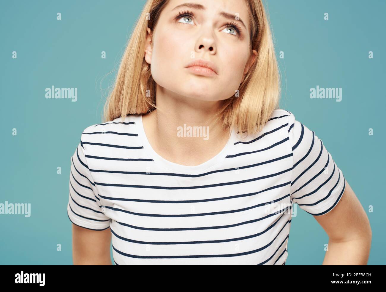 Emotional blonde woman on a blue background gestures with her hands a ...