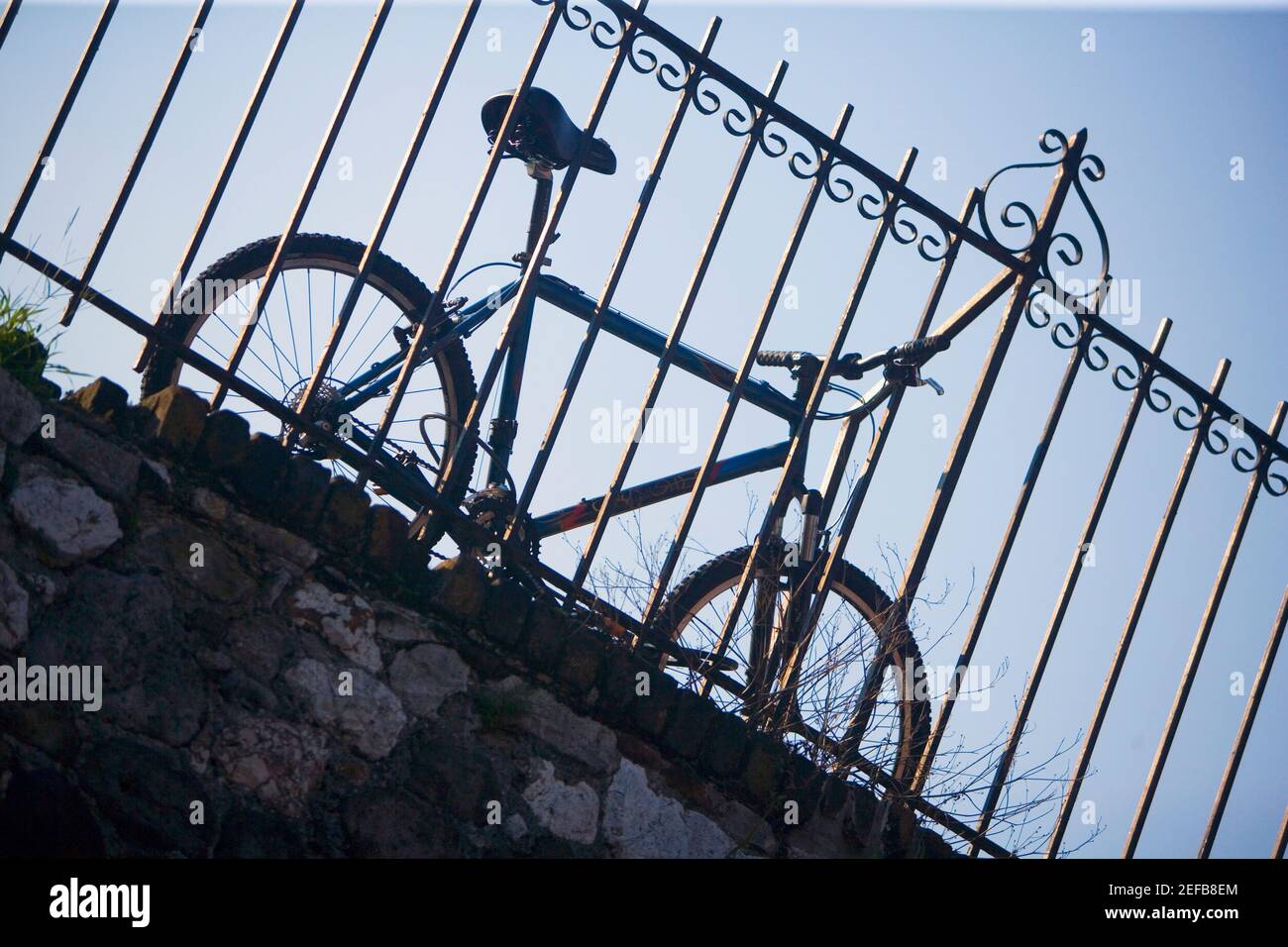 Low angle view of a bicycle leaning against a railing Stock Photo - Alamy