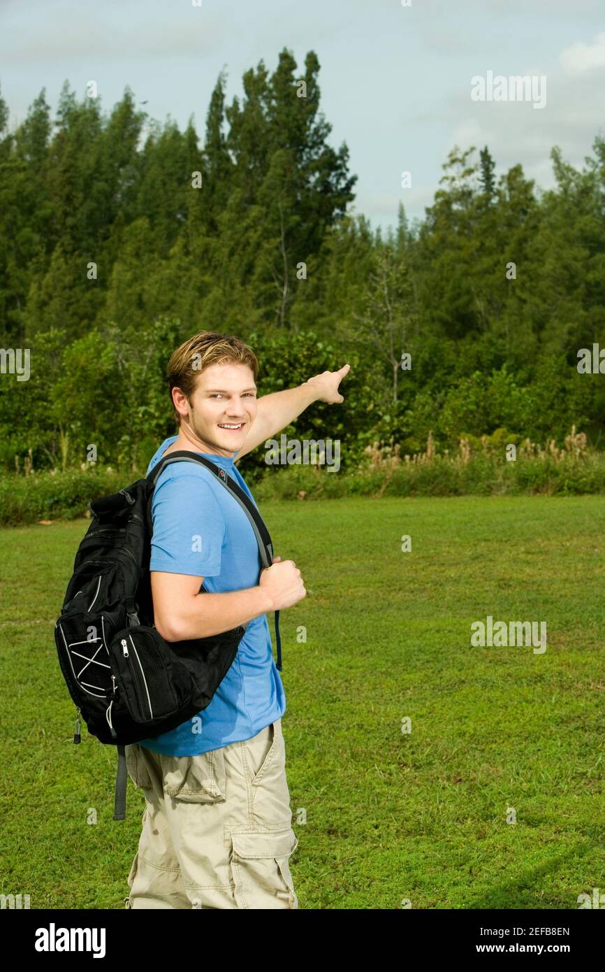 Portrait of a young man carrying a backpack pointing forward Stock ...