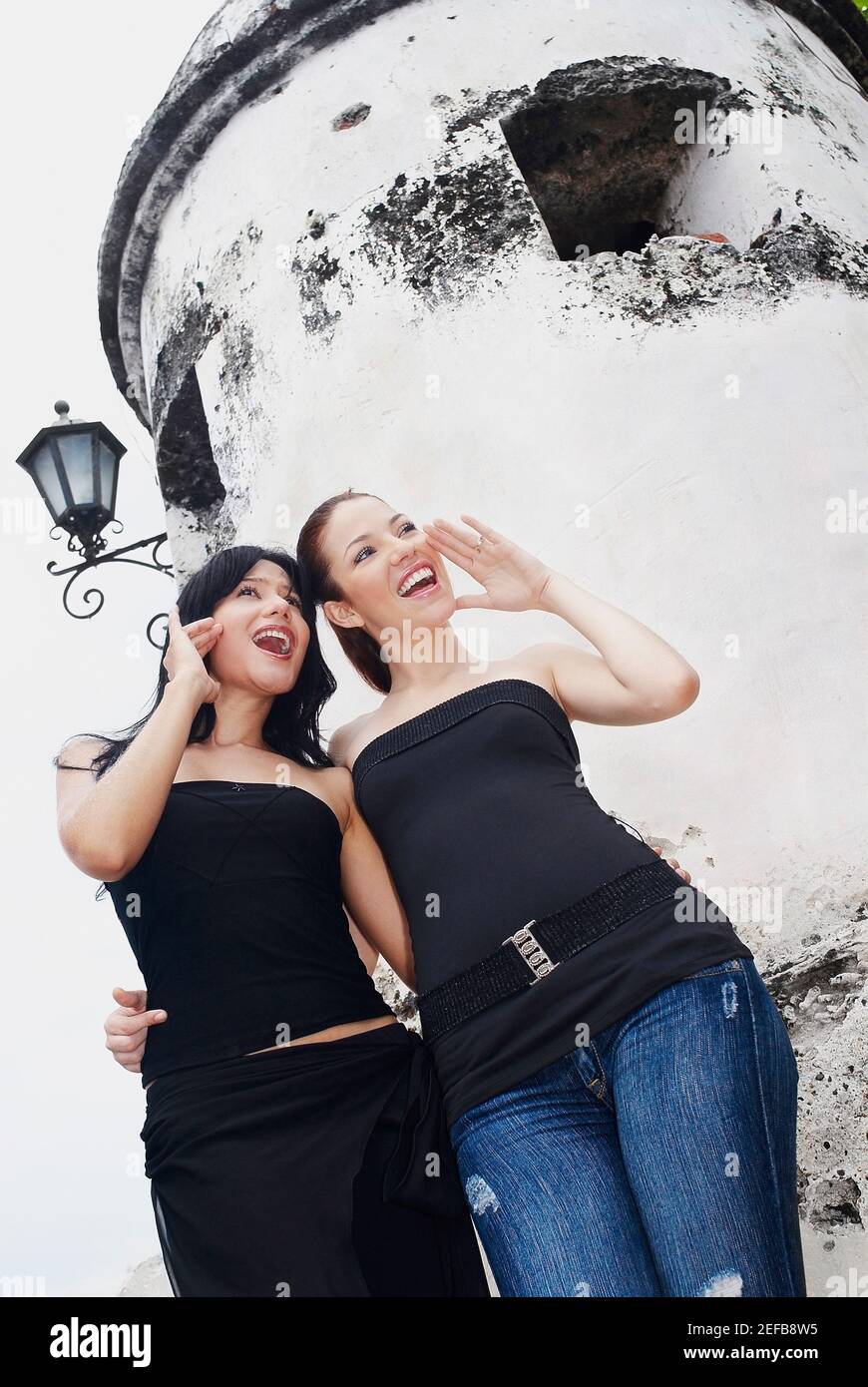 Low angle view of two young women shouting Stock Photo - Alamy