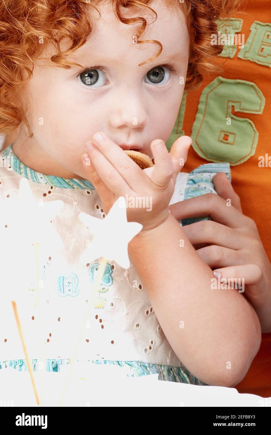 Portrait of a girl eating a biscuit Stock Photo - Alamy