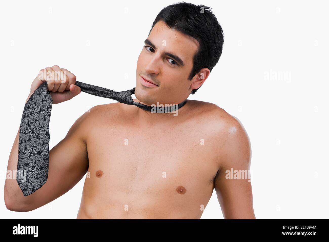 Portrait of a businessman pulling his tie Stock Photo - Alamy