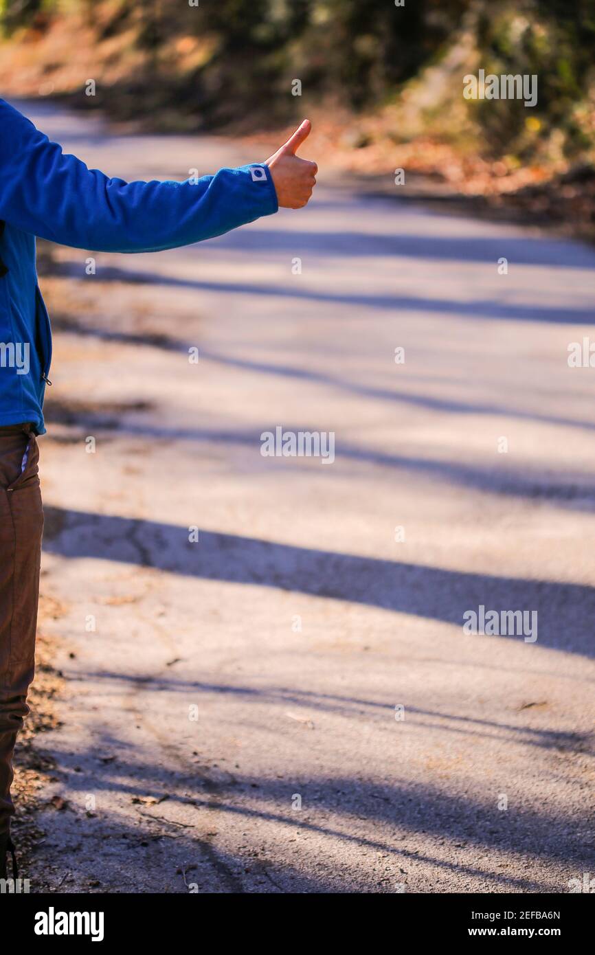 The Hitchhiking woman's hand on the beautiful road side Stock Photo - Alamy