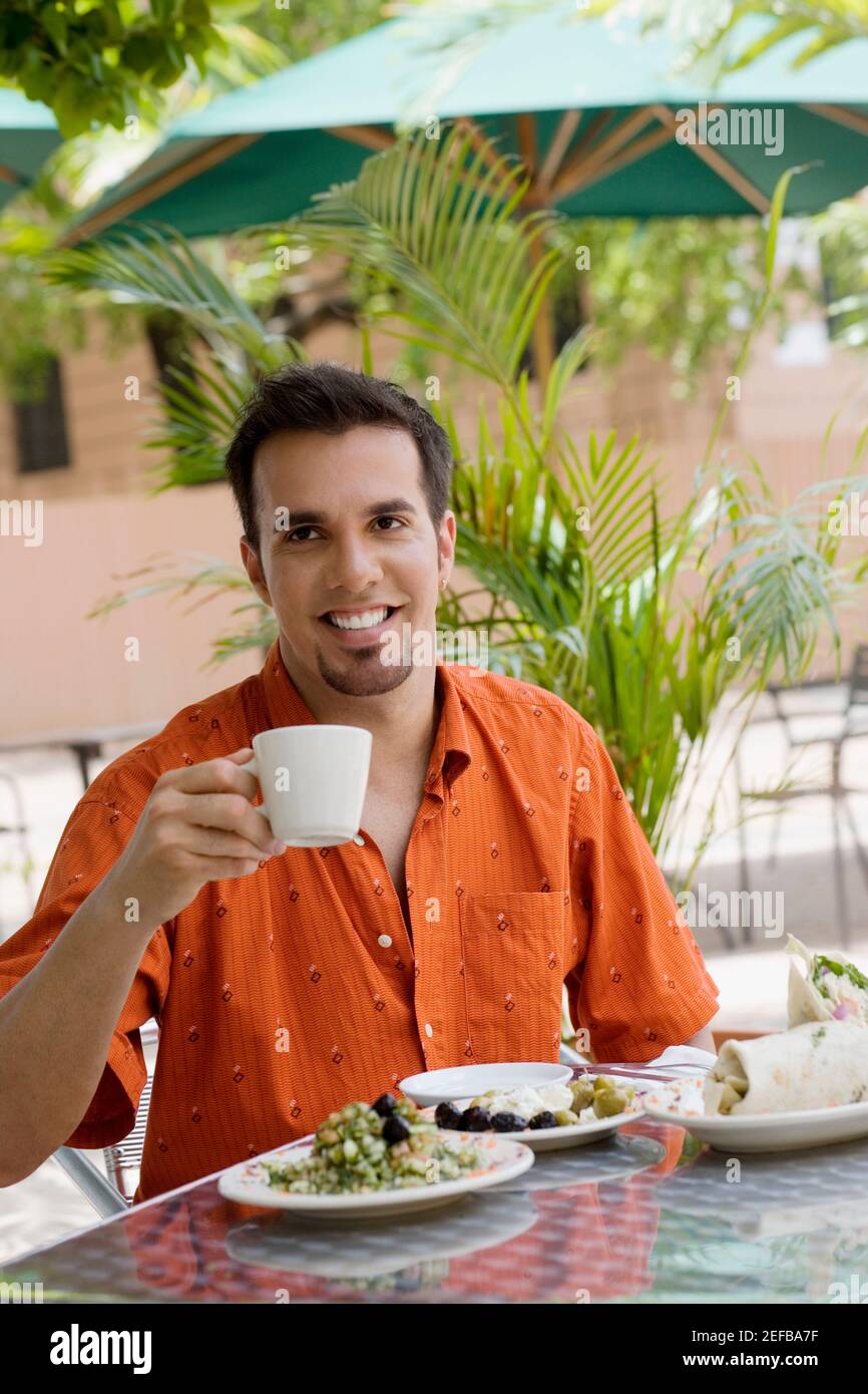 Portrait of a mid adult man drinking tea at a restaurant Stock Photo ...