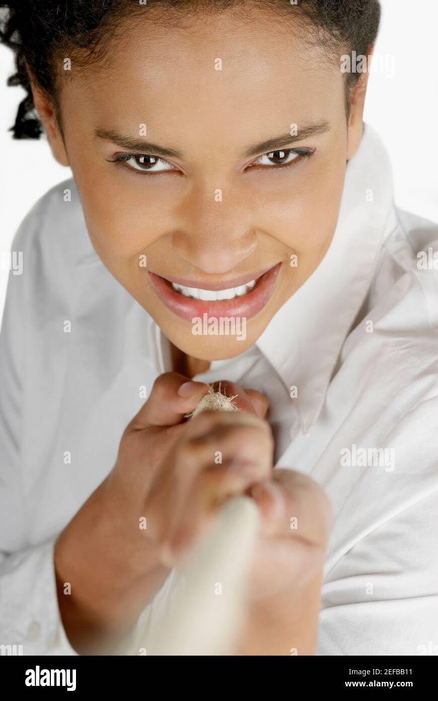Portrait of a young woman pulling a rope and smiling Stock Photo - Alamy