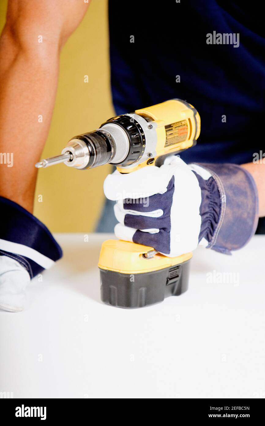 Mid section view of a man holding a drill machine Stock Photo - Alamy