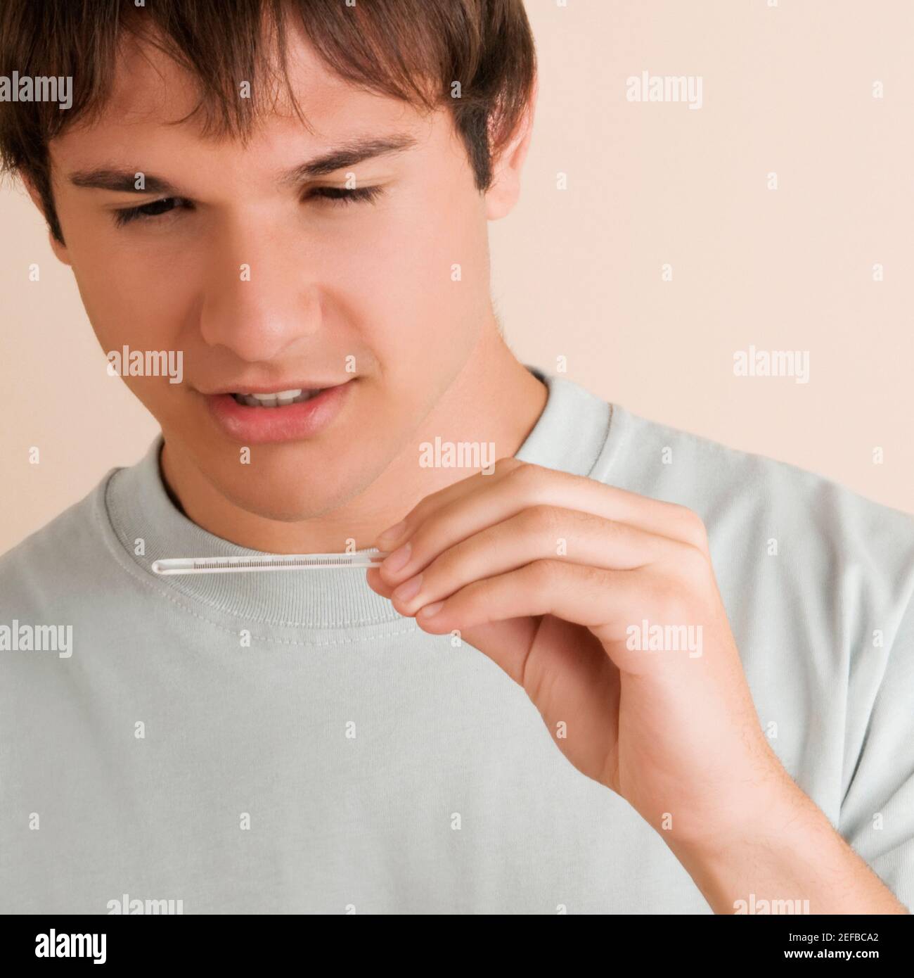 Close up of a young man checking the temperature on a thermometer Stock ...