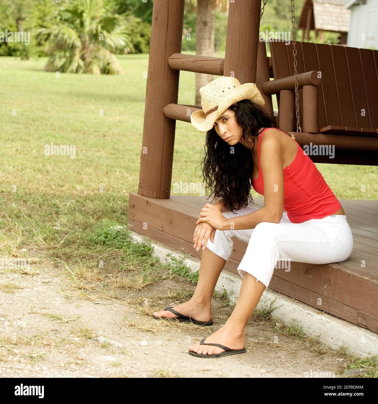 Side profile of a young woman sitting on the ledge Stock Photo - Alamy