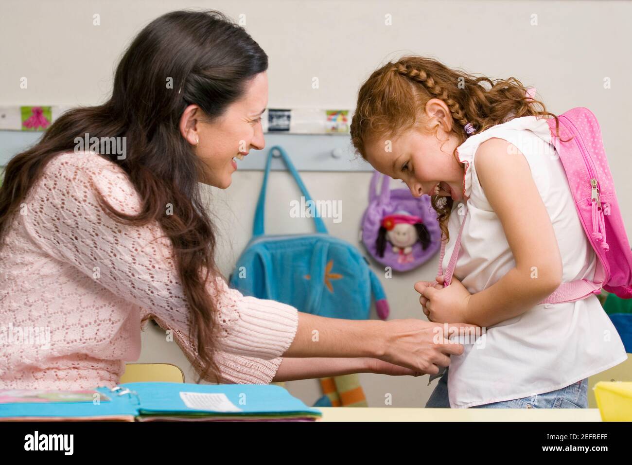 Side profile of a teacher and her student smiling Stock Photo - Alamy