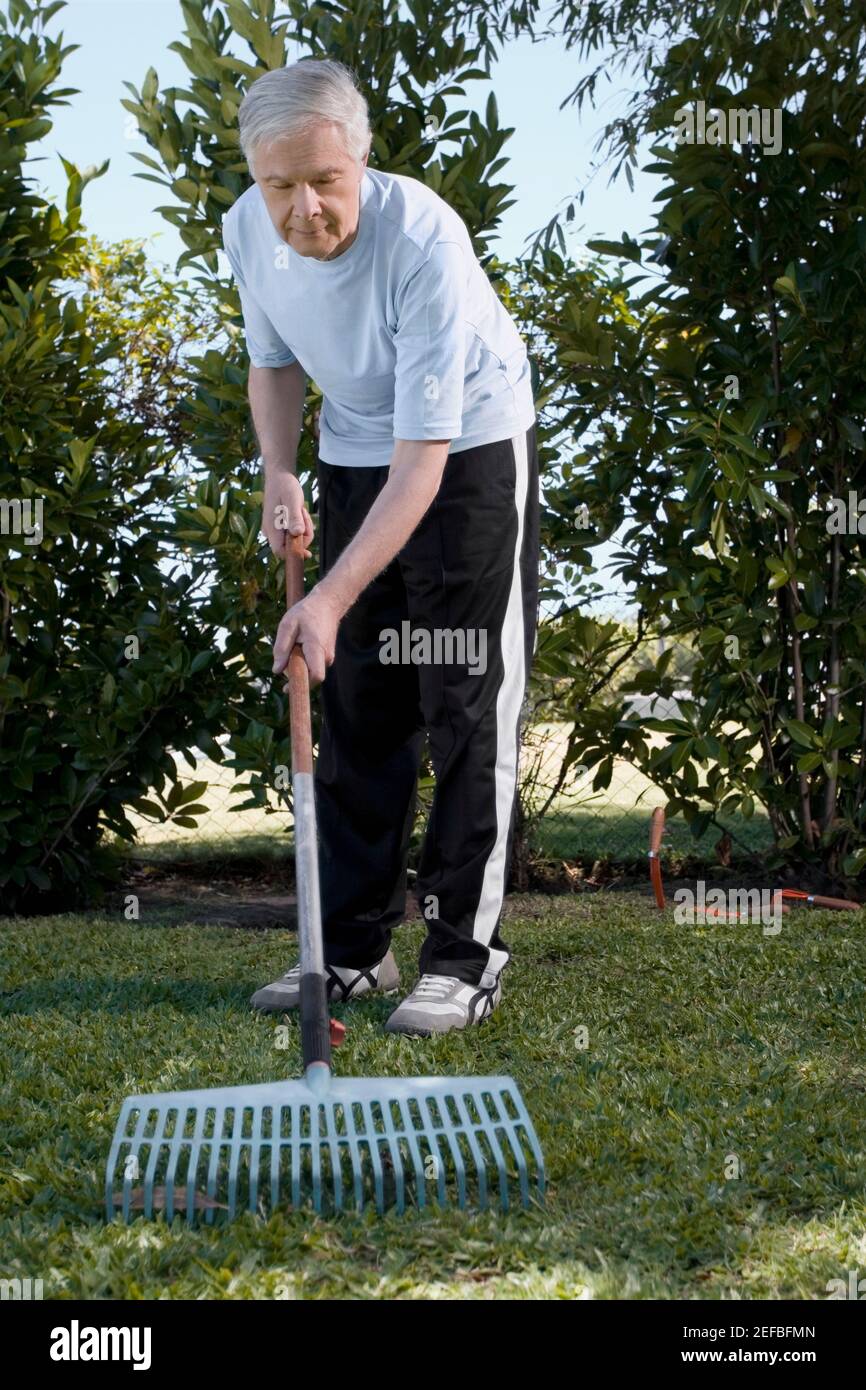 Male raking grass hi-res stock photography and images - Alamy