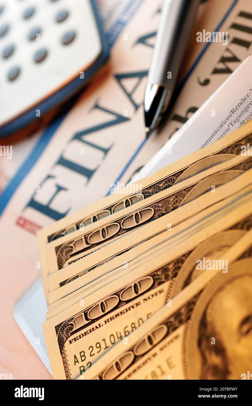United States currency, pen, financial section of newspaper and ...