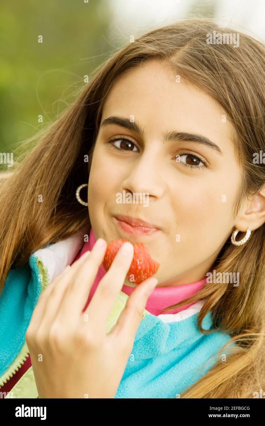 Portrait of a girl eating a strawberry Stock Photo - Alamy