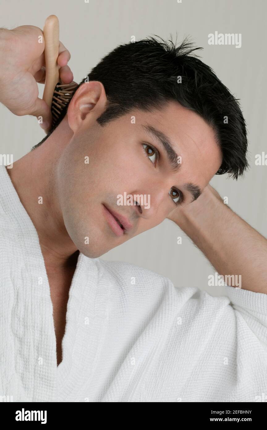 Close-up of a young man combing his hair Stock Photo - Alamy