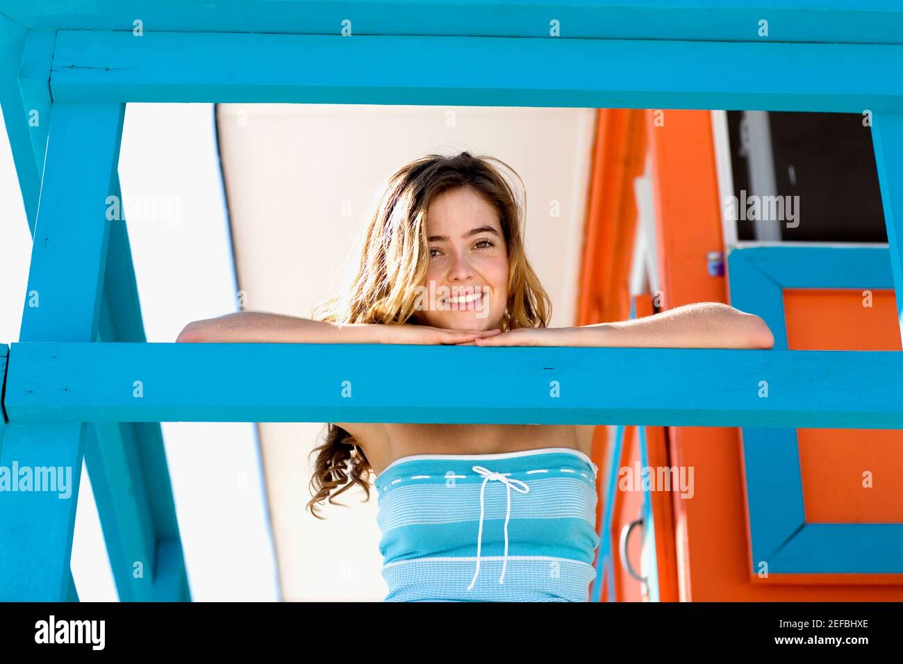 Portrait of a young woman leaning against a railing and smiling Stock ...