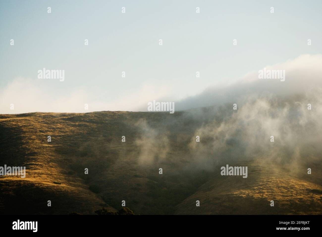 Clouds rolling over a hill range Stock Photo - Alamy