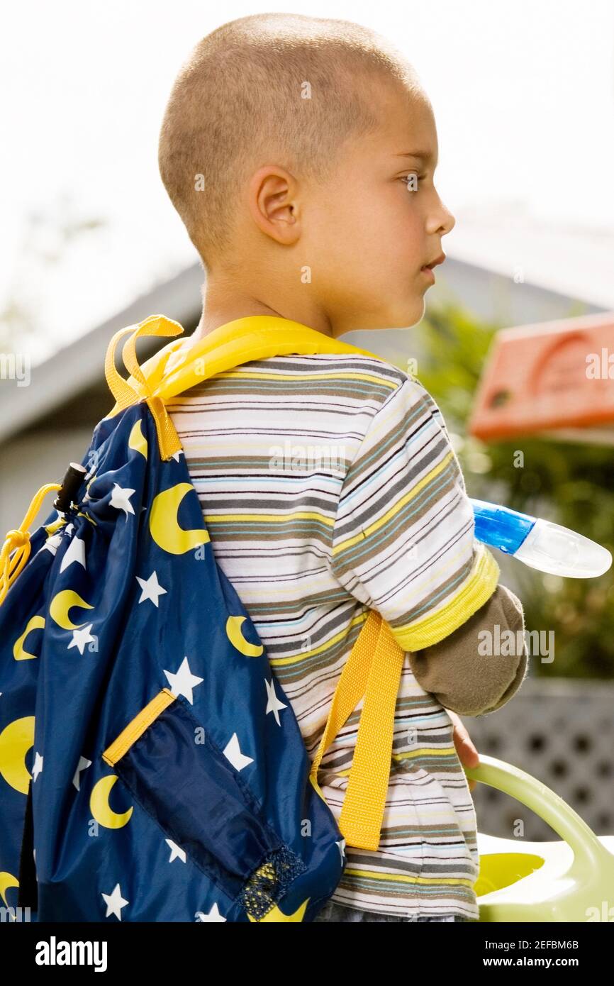 Side profile of a boy carrying a backpack Stock Photo - Alamy