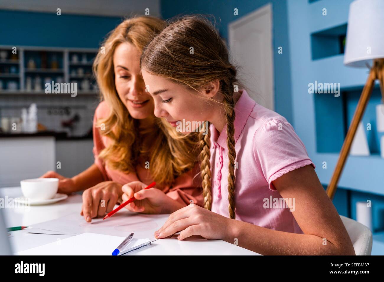 Beautiful cute girl at elementary school doing homeworks at home - Mom ...