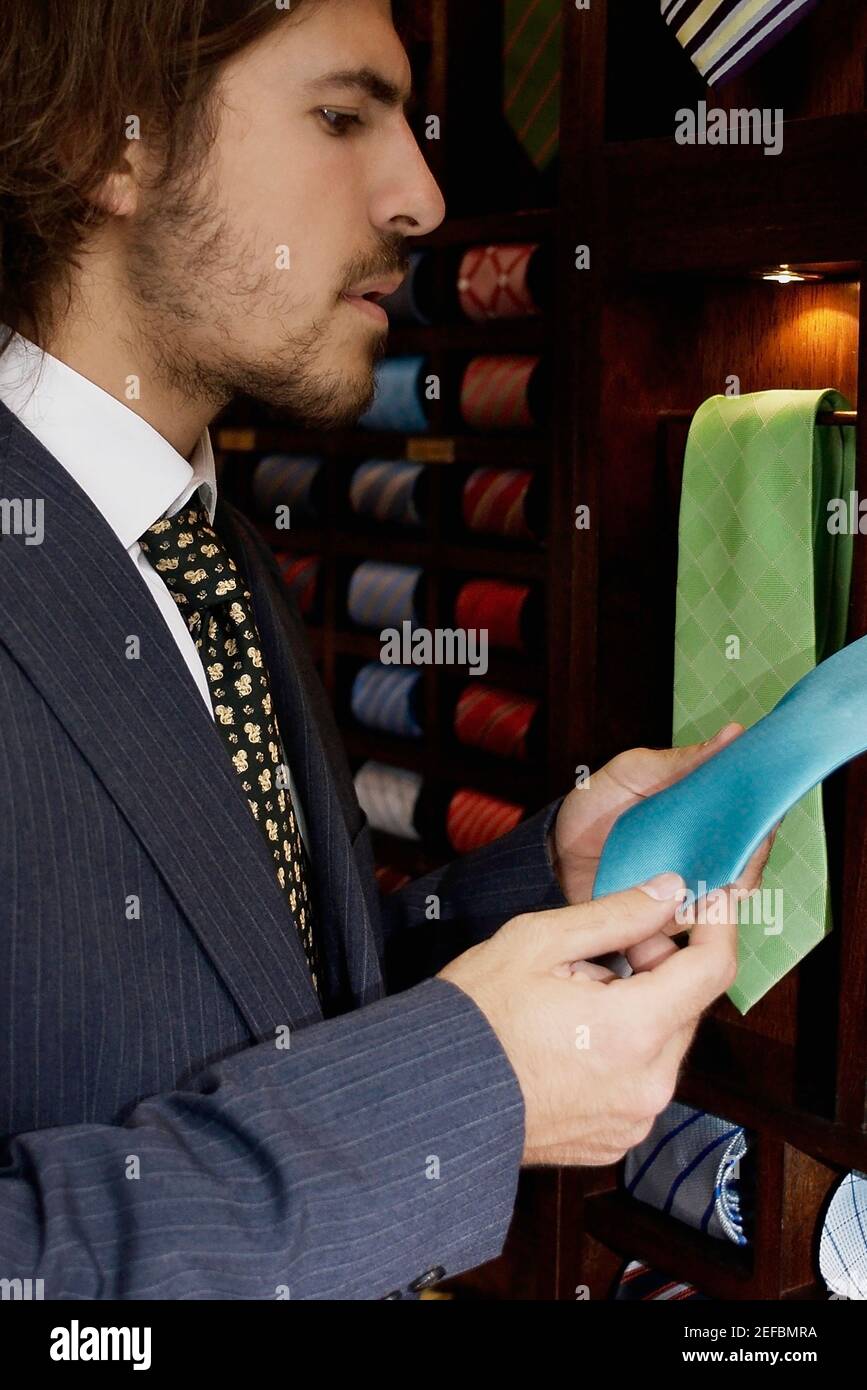 Side profile of a businessman choosing a tie in a clothing store Stock ...