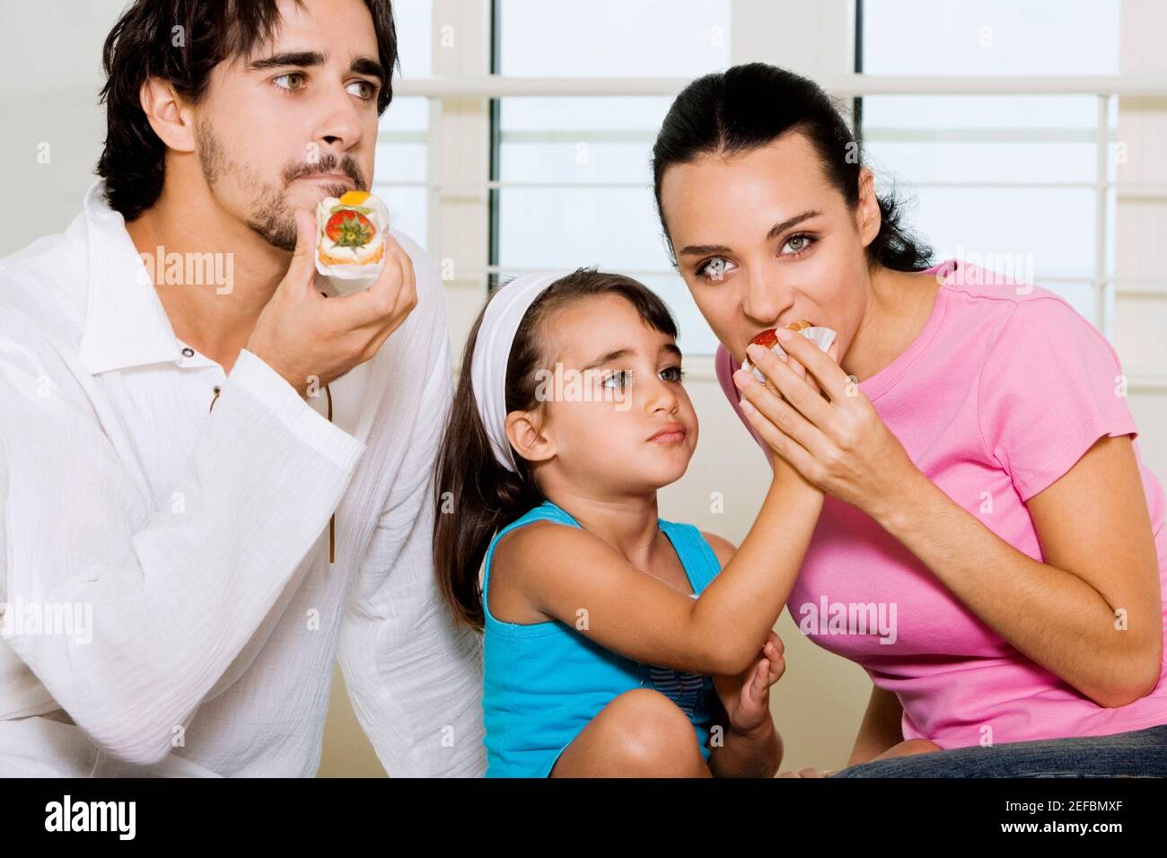 Close-up of a young man eating a pastry Stock Photo - Alamy
