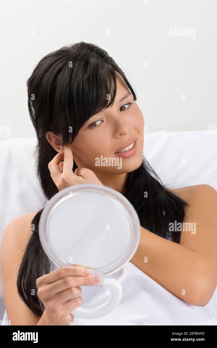 Female patient examining her face in a mirror Stock Photo - Alamy