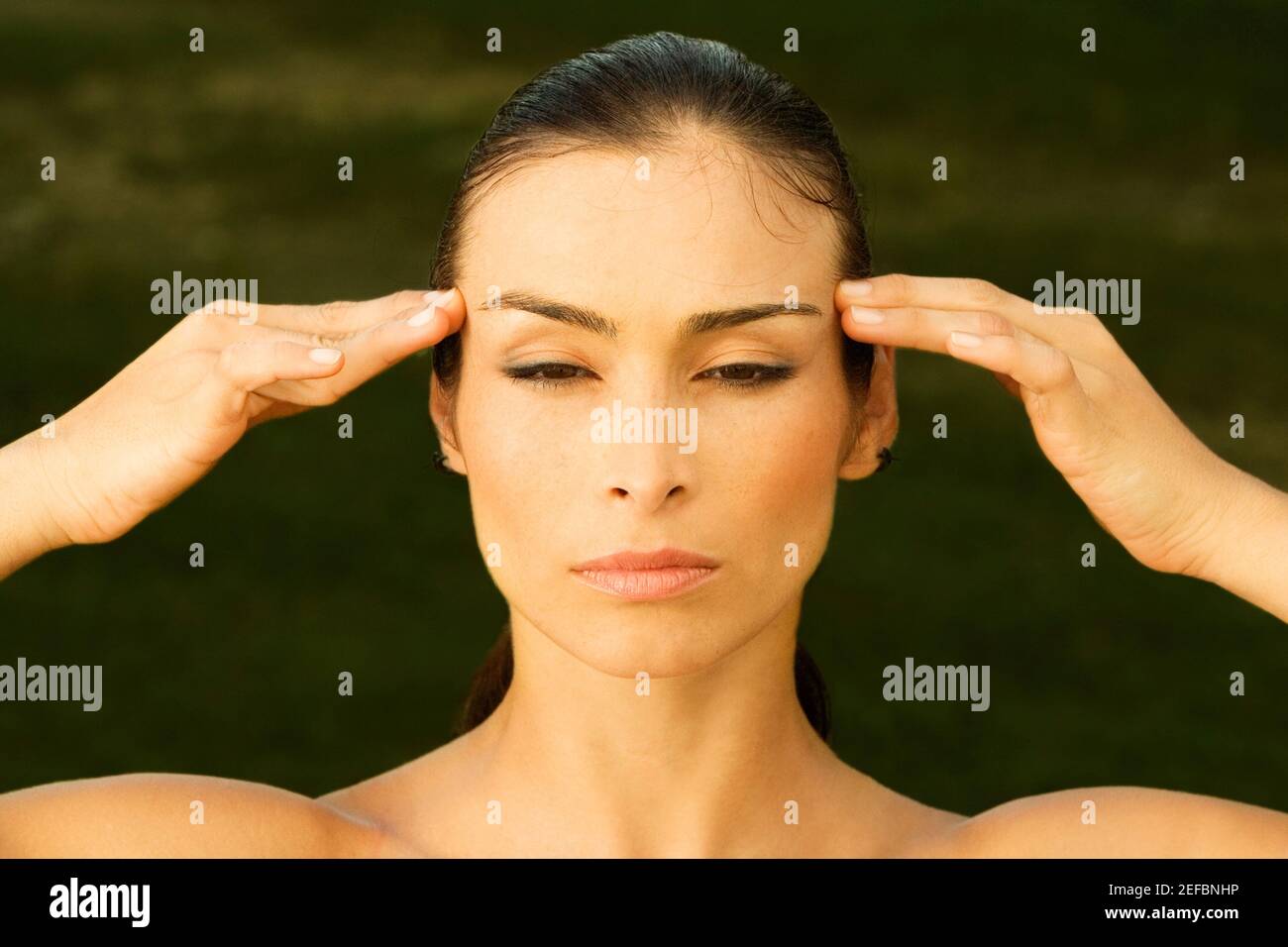 Close-up of a mid adult woman with her hands on her head Stock Photo ...