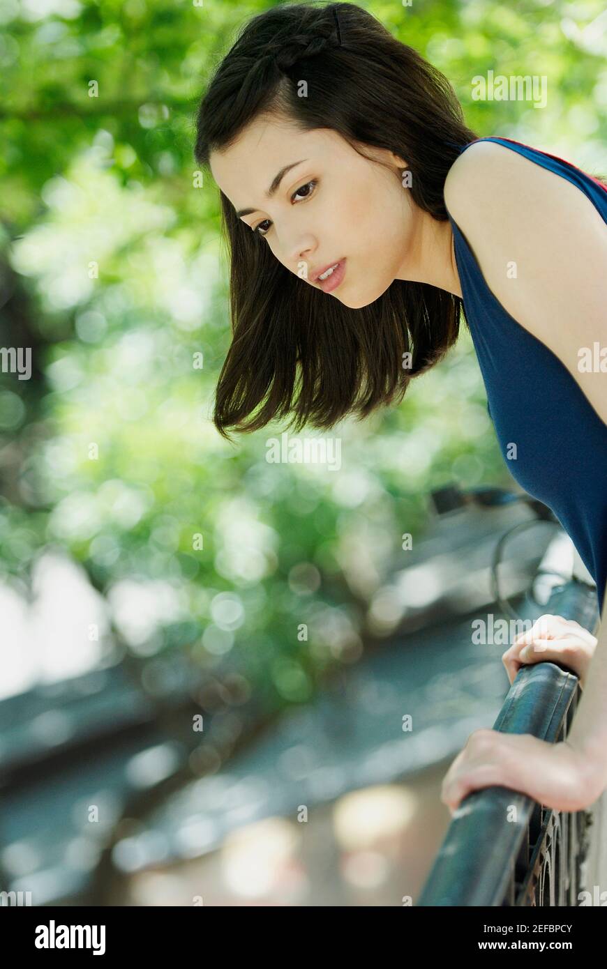 Close up of a young woman bending forward over a railing Stock Photo ...