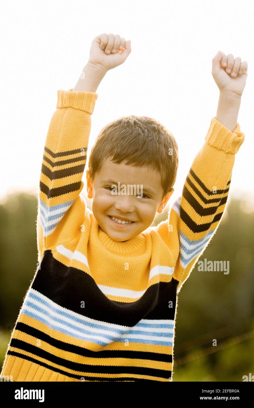 Portrait of a boy with his arms raised Stock Photo - Alamy