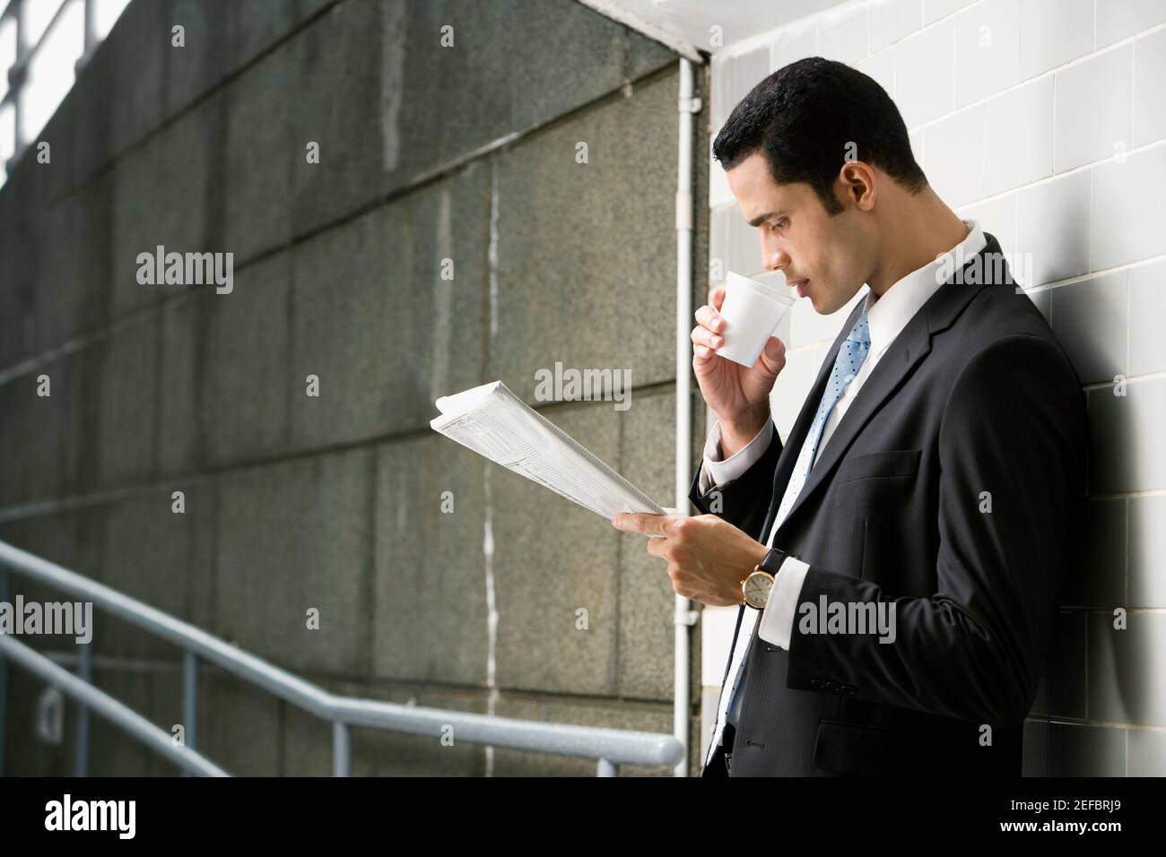 Side profile of a businessman reading a newspaper Stock Photo - Alamy